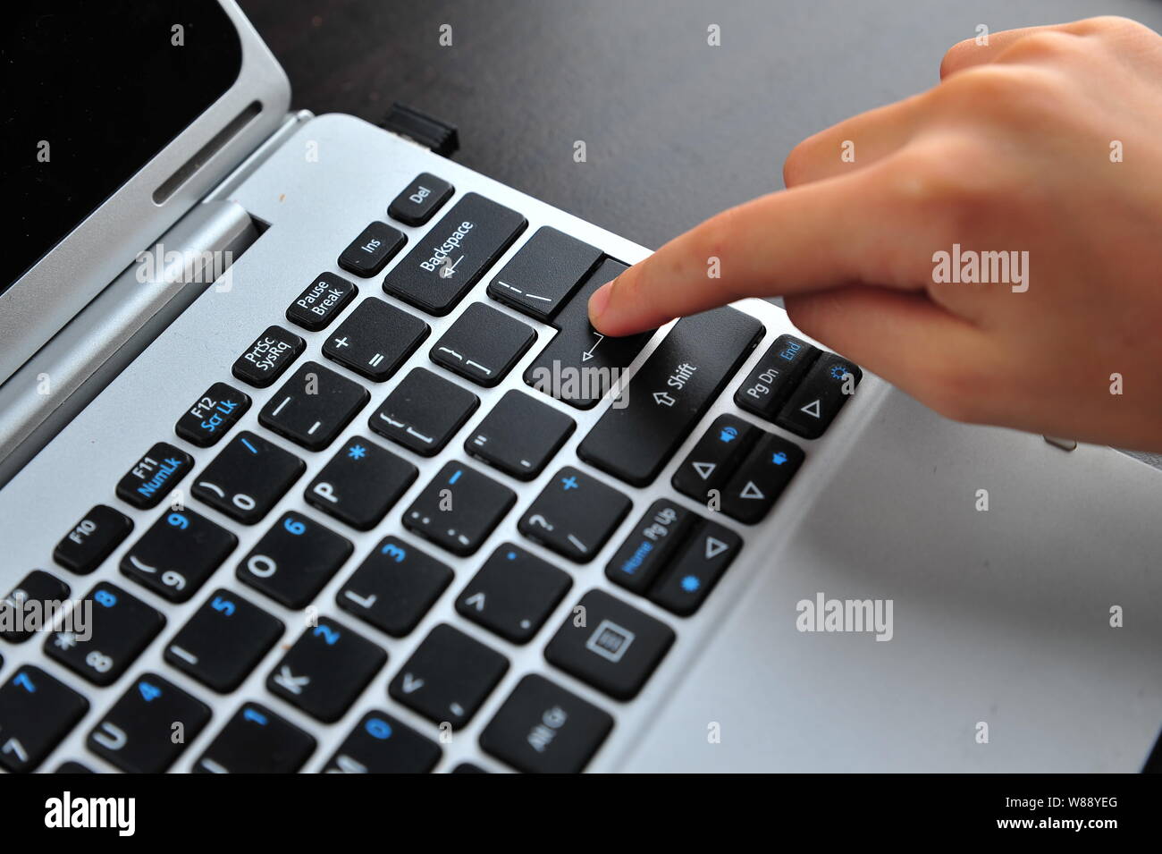 Woman hand touching laptop computer keyboard - Focus on the keyboard Stock Photo - Alamy