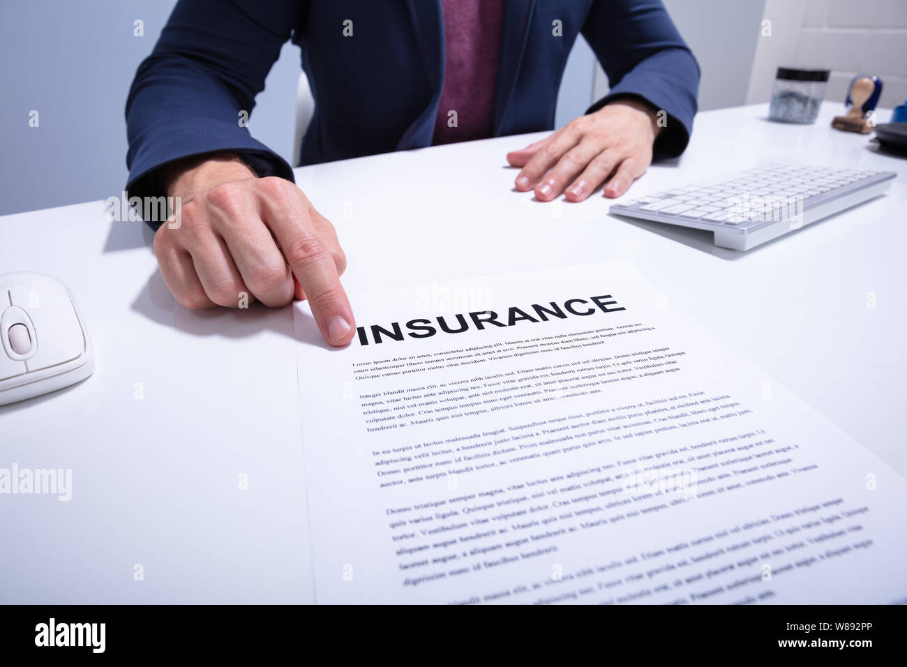 Mid Section Of A Businessman Showing Insurance Document Over White Desk ...