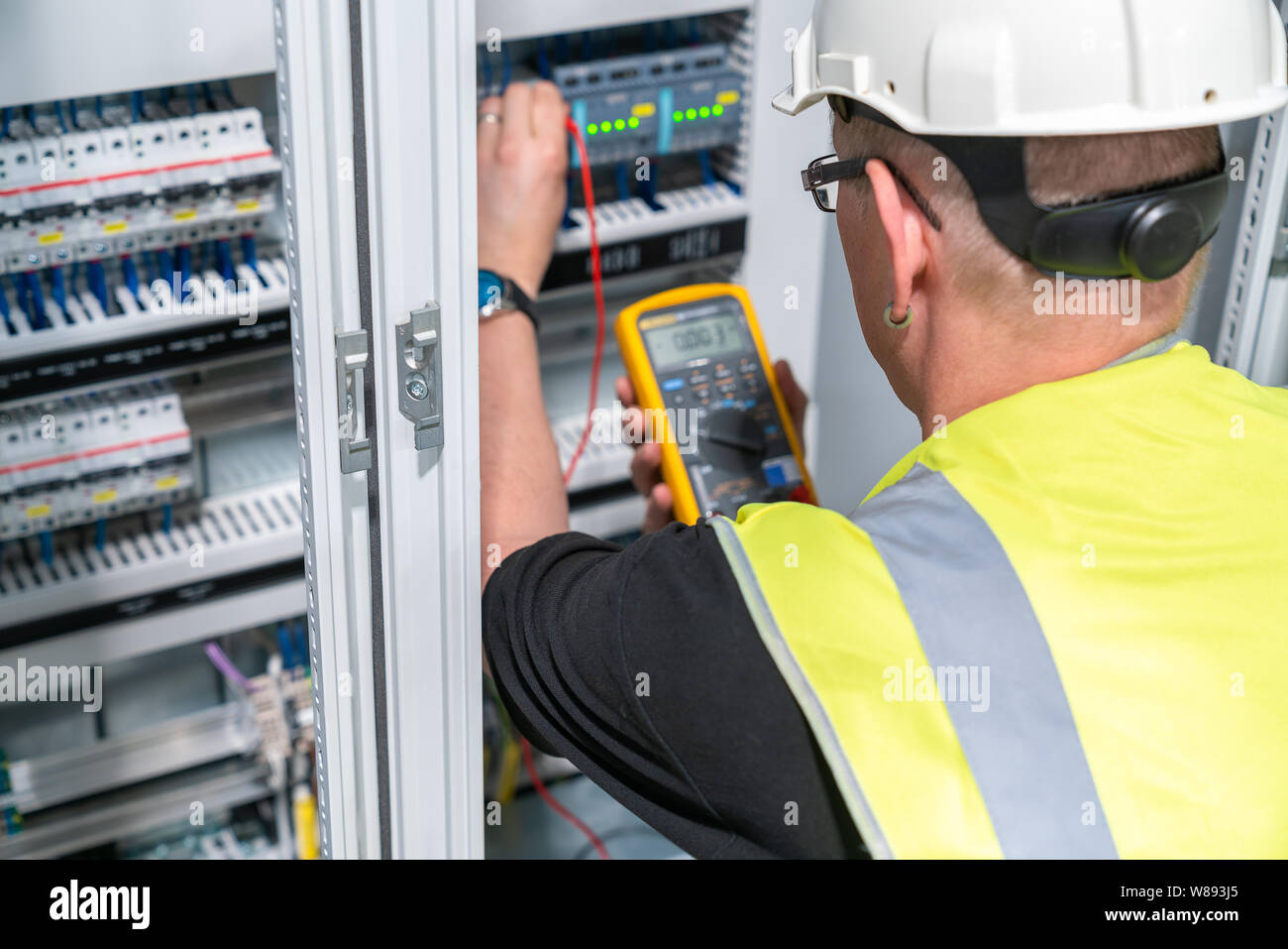 electrical engineer performs a measurement in a control cabinet Stock ...
