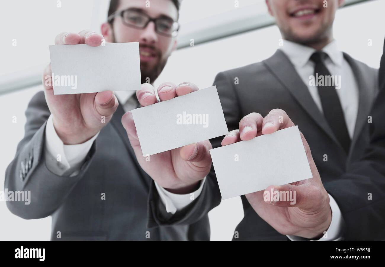 three young business partners showing their business cards Stock Photo ...