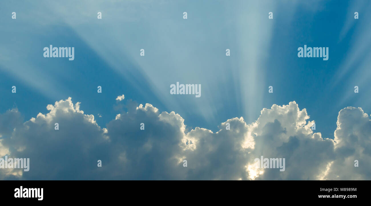 Optimistic sunset rays behind the clouds. Glow in the sky. Symbol of ...