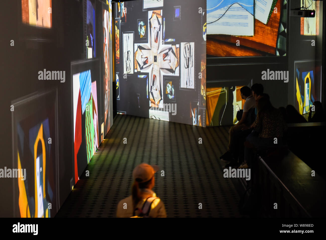 Visitors admire a multimedia projection in one of the exhibition rooms ...