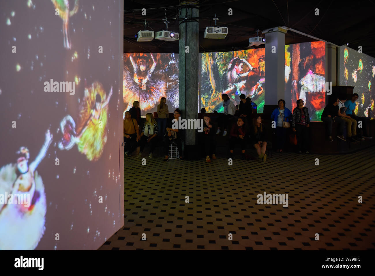 Visitors admire a multimedia projection in one of the exhibition rooms ...