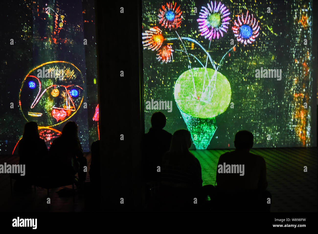 Visitors admire a multimedia projection in one of the exhibition rooms ...