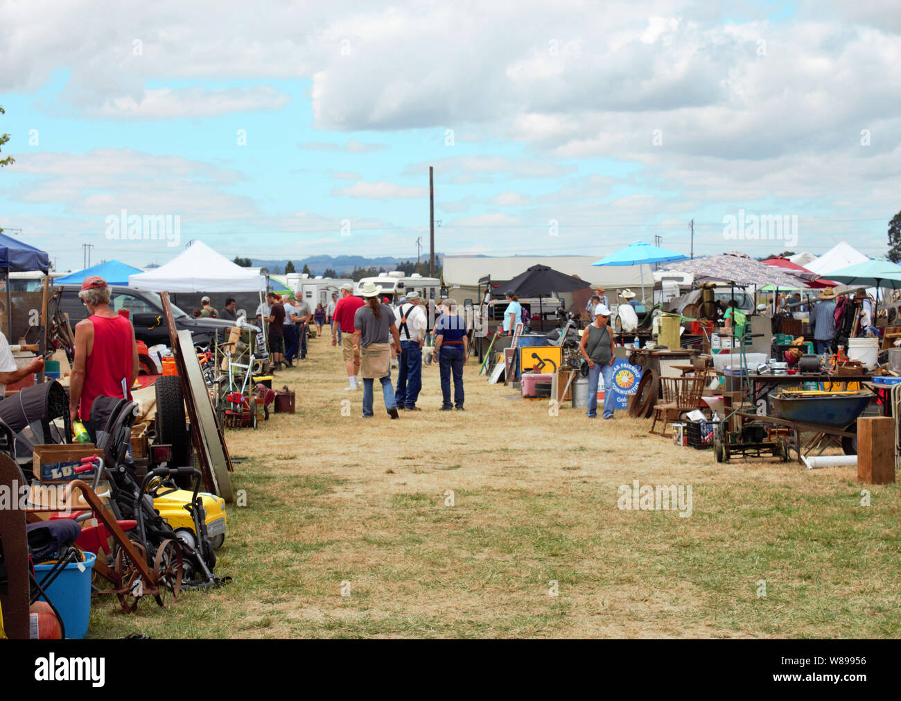 Booths line the walkway at a local antiques fair Stock Photo - Alamy