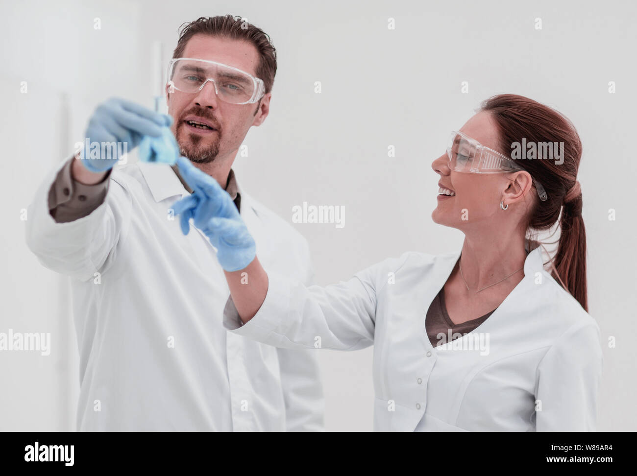 two successful scientists biologist looking at the flask with the ...