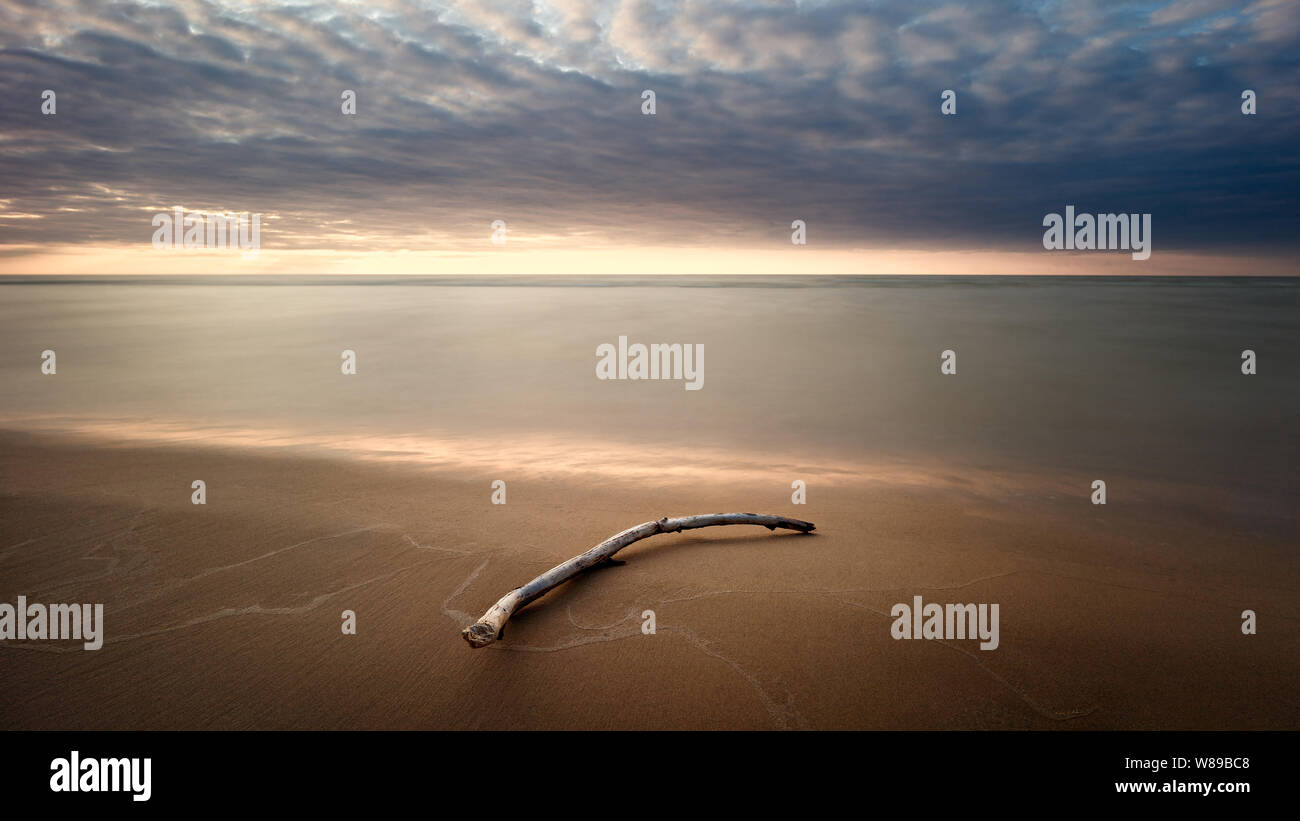 Long exposure of colourful sunset on the beach with sky motion for ...