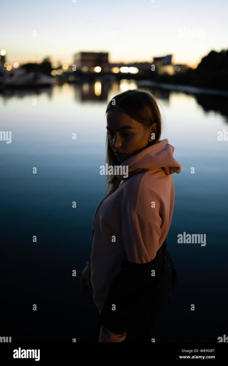 Blonde woman portrait standing by the river at night Stock Photo - Alamy