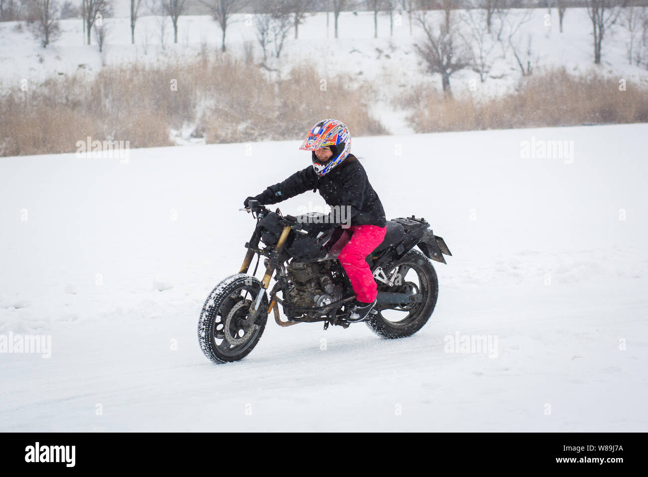 A girl rides a motorcycle on a frozen lake Stock Photo - Alamy