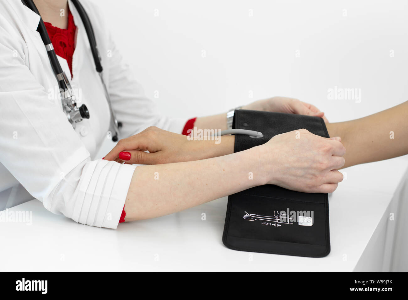 Professional female doctor putting on device for measuring pressure on ...