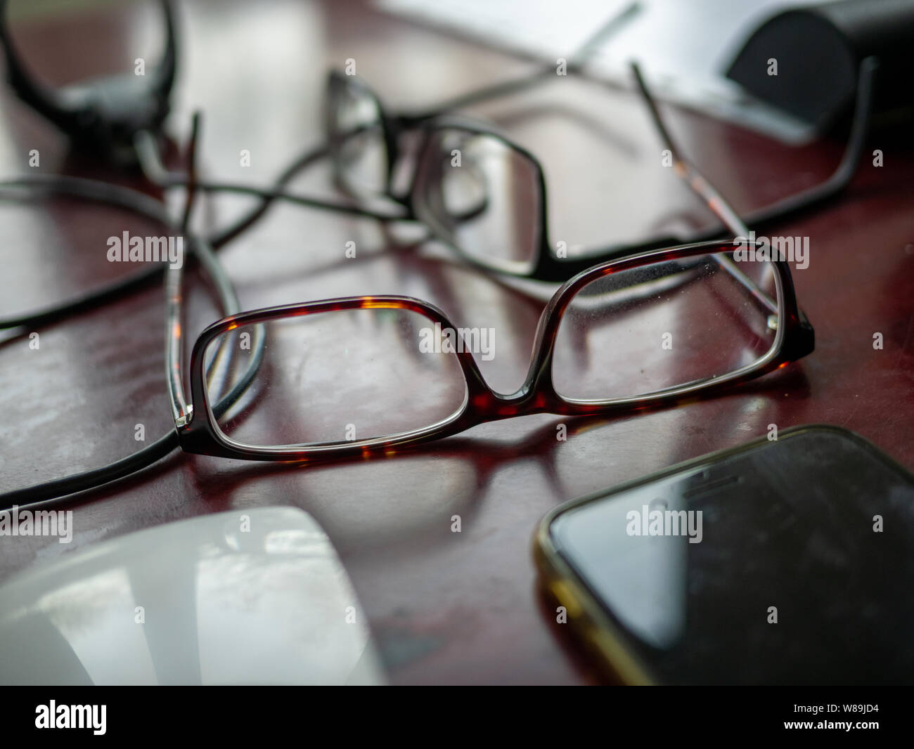 glasses on desk with reflections Stock Photo - Alamy