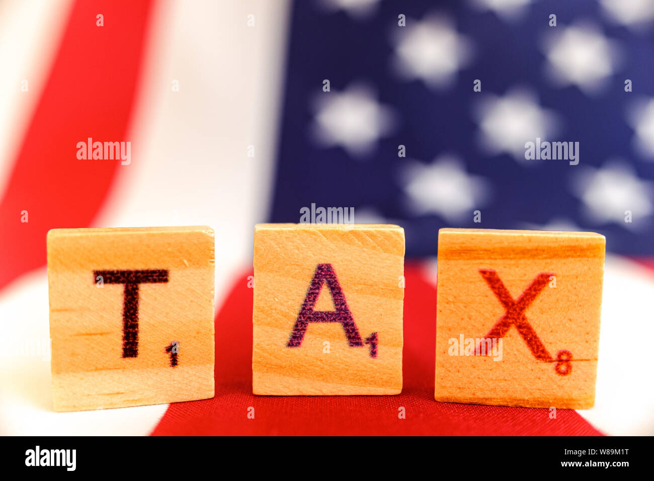 Word Tax on unfocused background of an American flag Stock Photo - Alamy