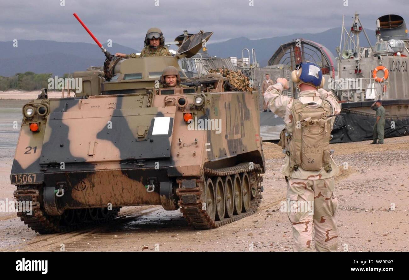 A Navy beachmaster from Assault Craft Unit 5 directs an Australian ...