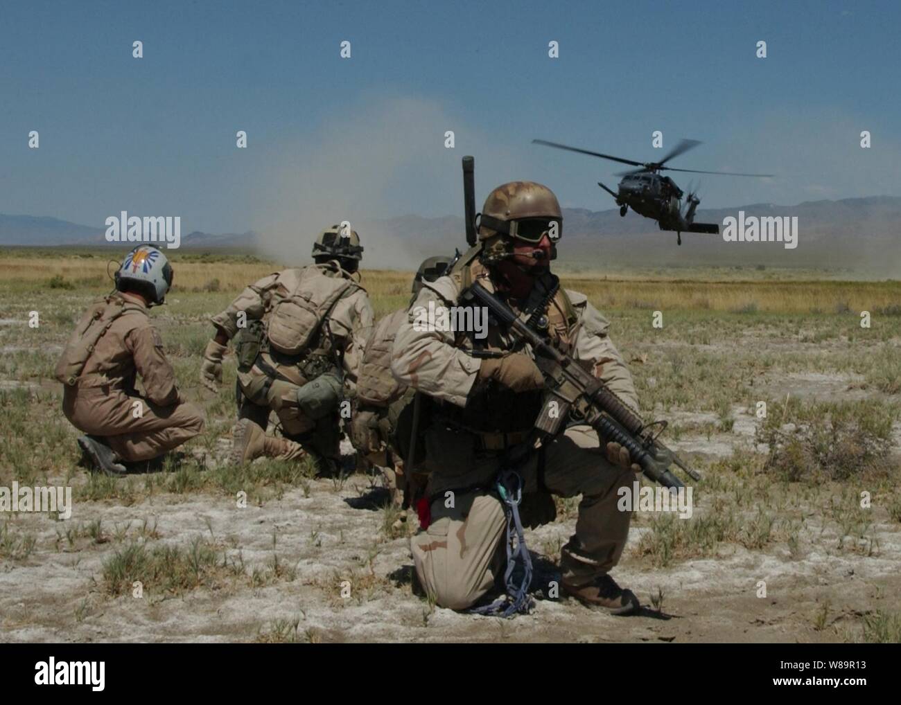 U.S. Air Force Pararescuemen and a simulated survivor watch as an HH ...