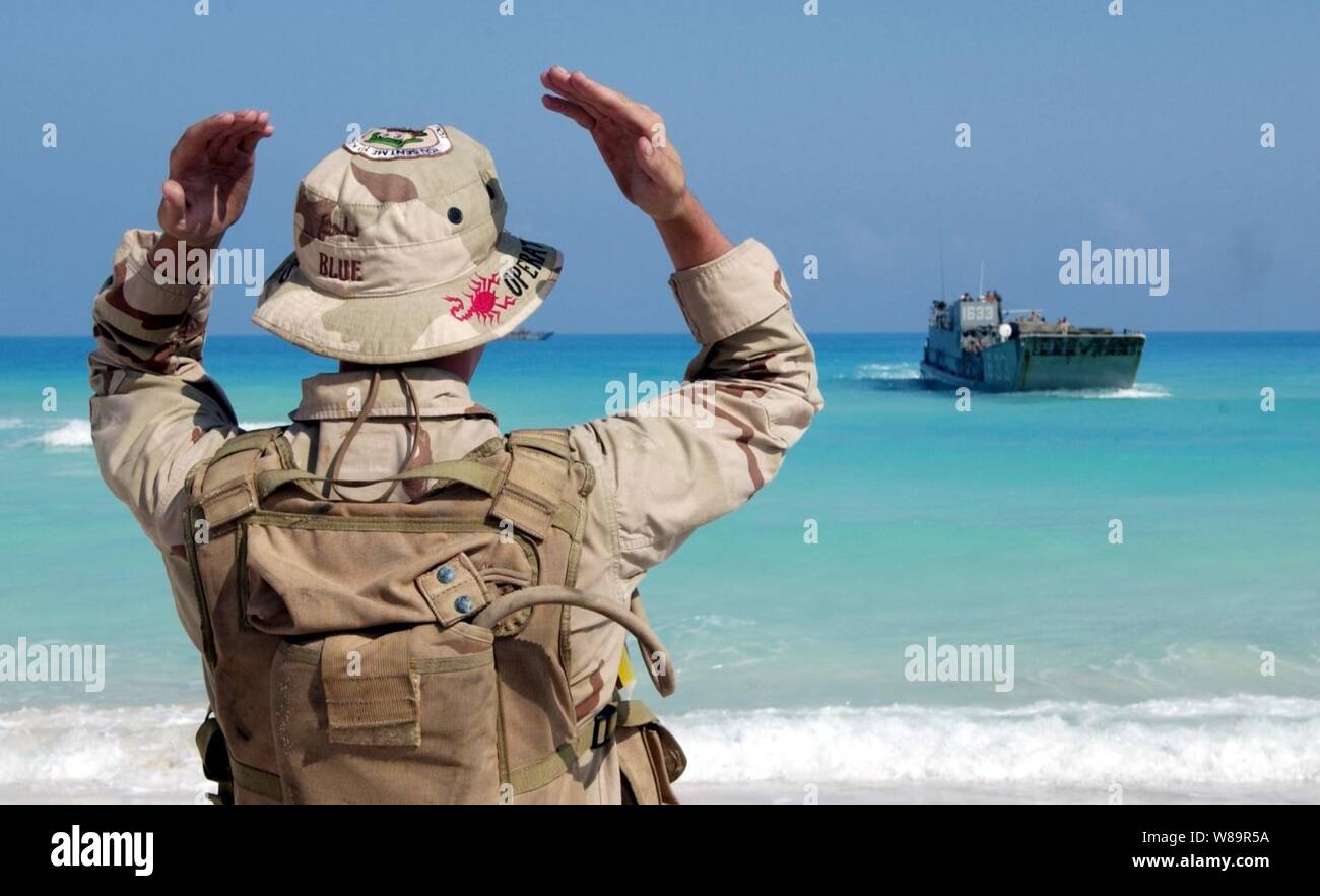 A U.S. Navy beach master from the USS Tarawa (LHA 1) guides a landing ...