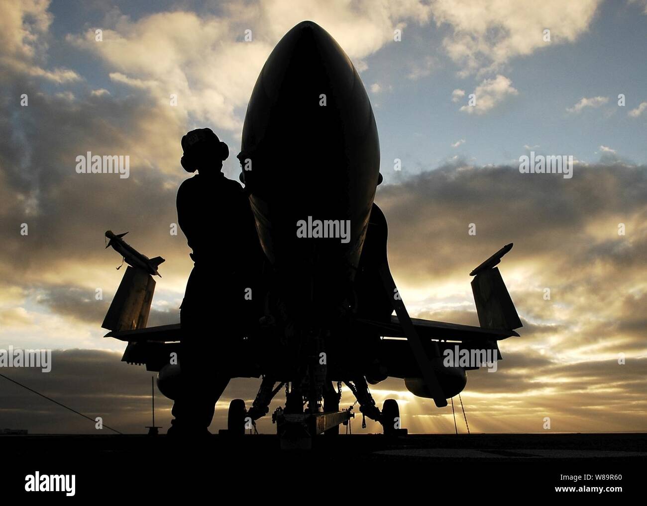 A U.S. Navy sailor cleans the nose of an F/A-18F Super Hornet as part ...