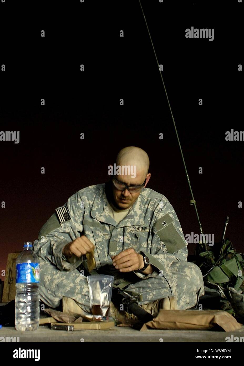 A U.S. Army soldier eats a Meal, Ready to Eat on the tarmac at Camp ...