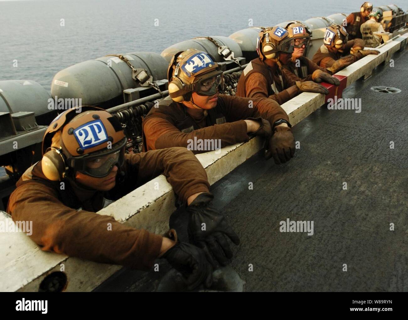 U.S. Navy plane captains watch flight operations from the flight deck ...