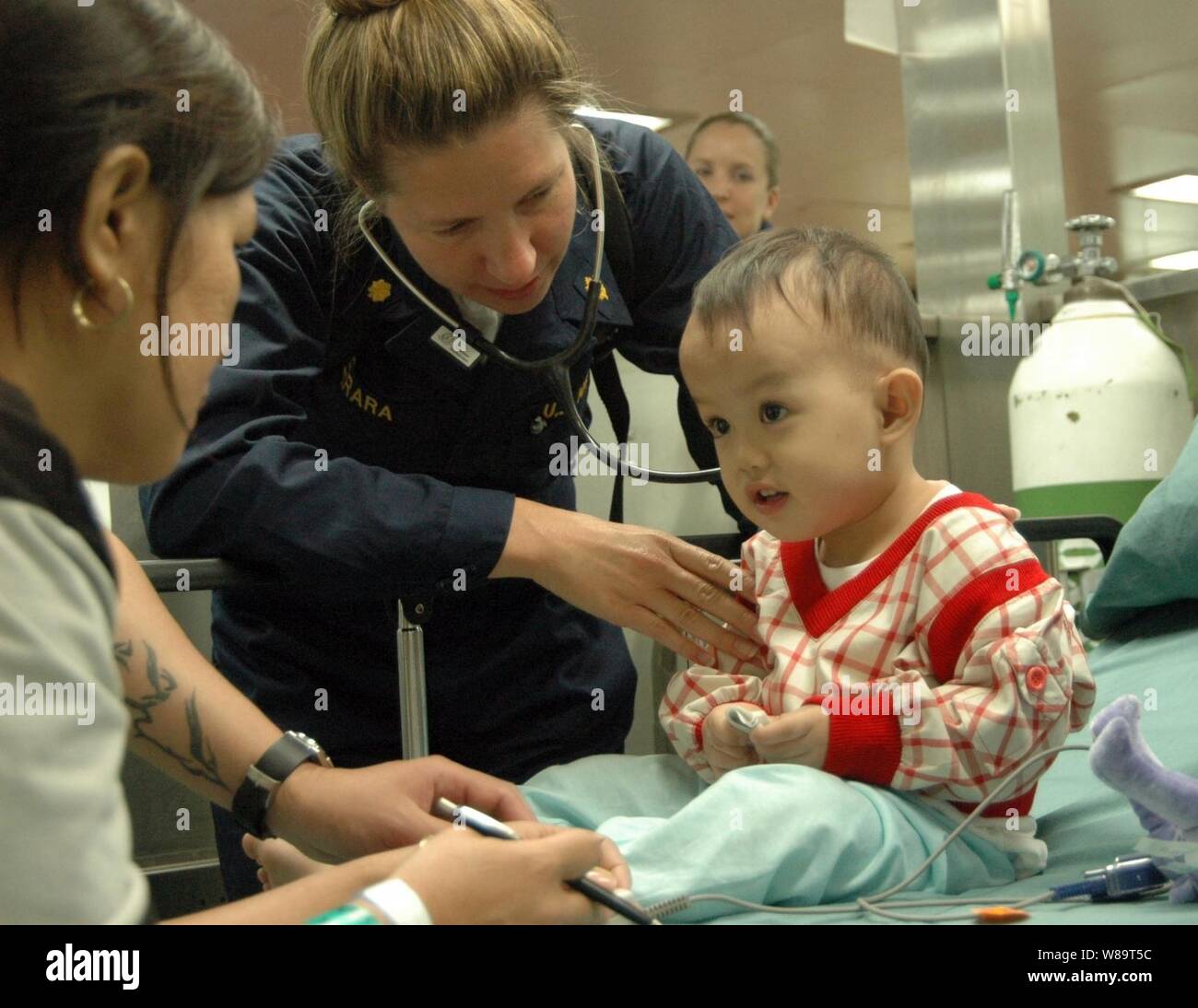 U.S. Navy Lt. Cmdr. Elizabeth Ferrara checks a boy's vital signs ...