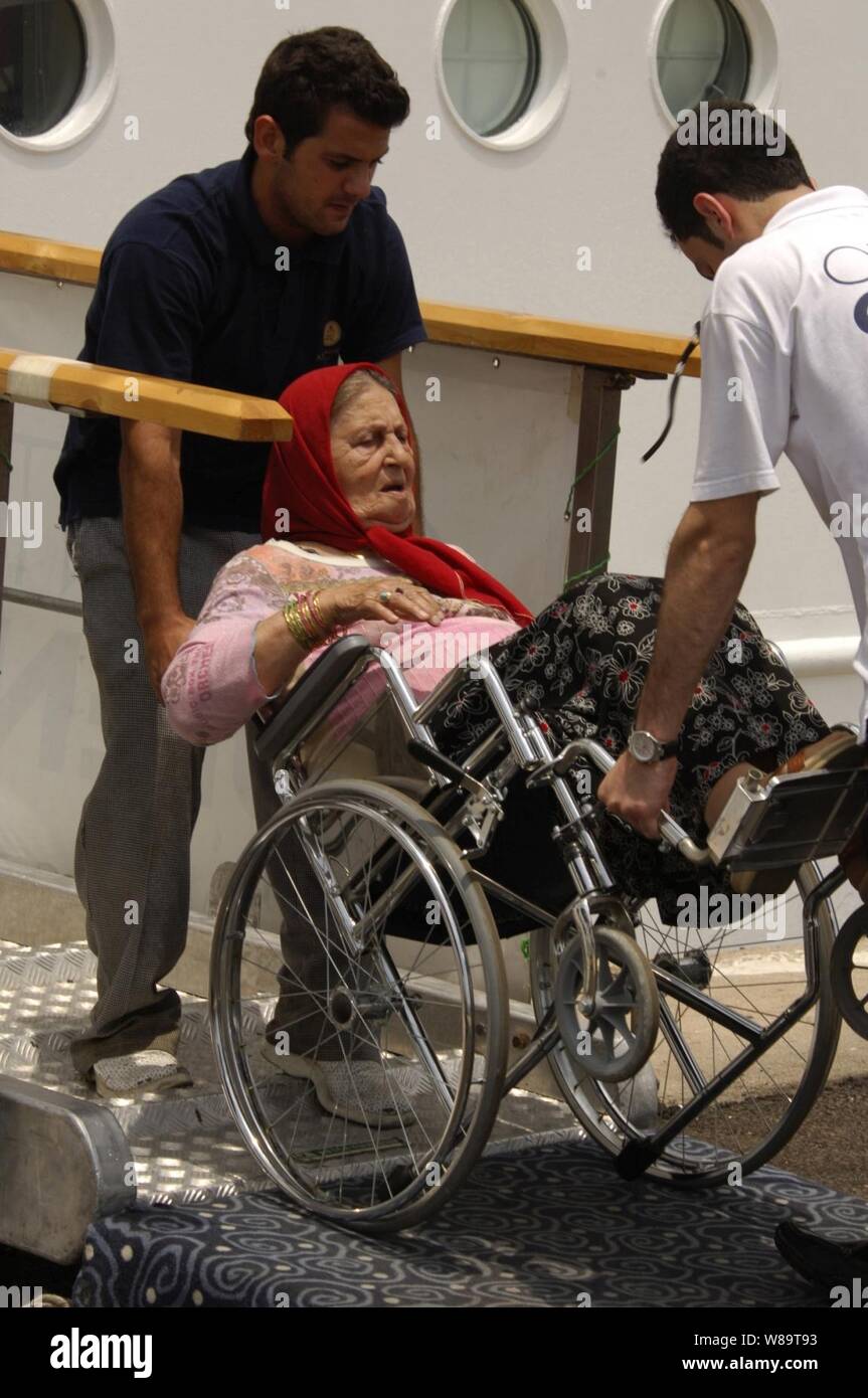 Crewmembers from the cruise ship Orient Queen assist a U.S. citizen as ...