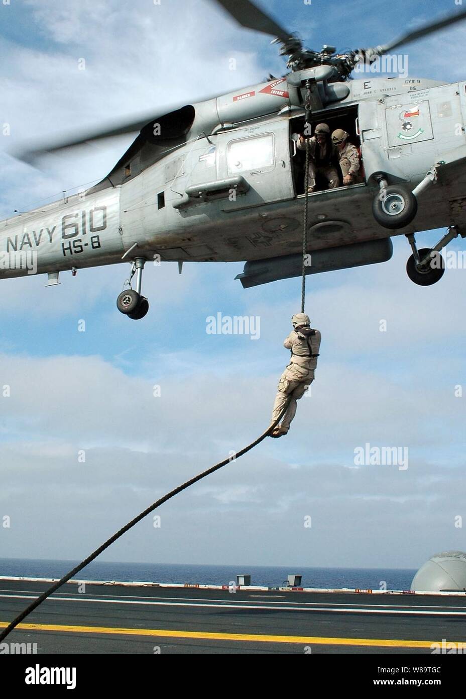 A U.S. Navy Explosive Ordnance Disposalman does a fast rope descent ...