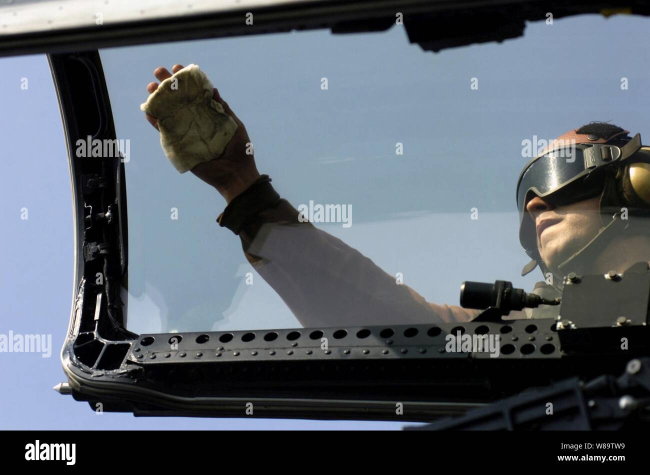 U.S. Navy Airman James Lapoint cleans the canopy of an F/A-18E Super ...