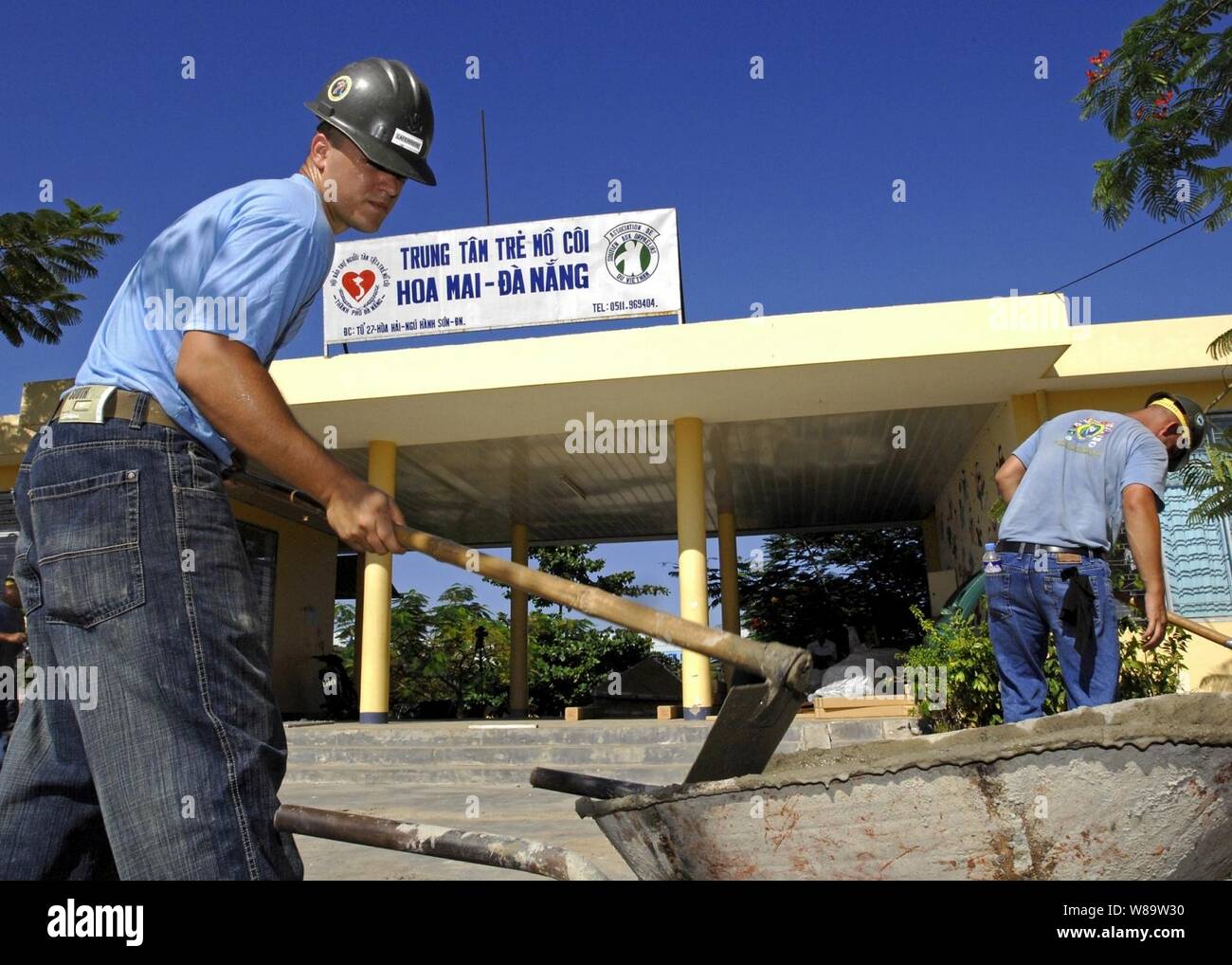 U.S. Navy Seabee Petty Officer 3rd Class Brian Laferriere mixes cement ...