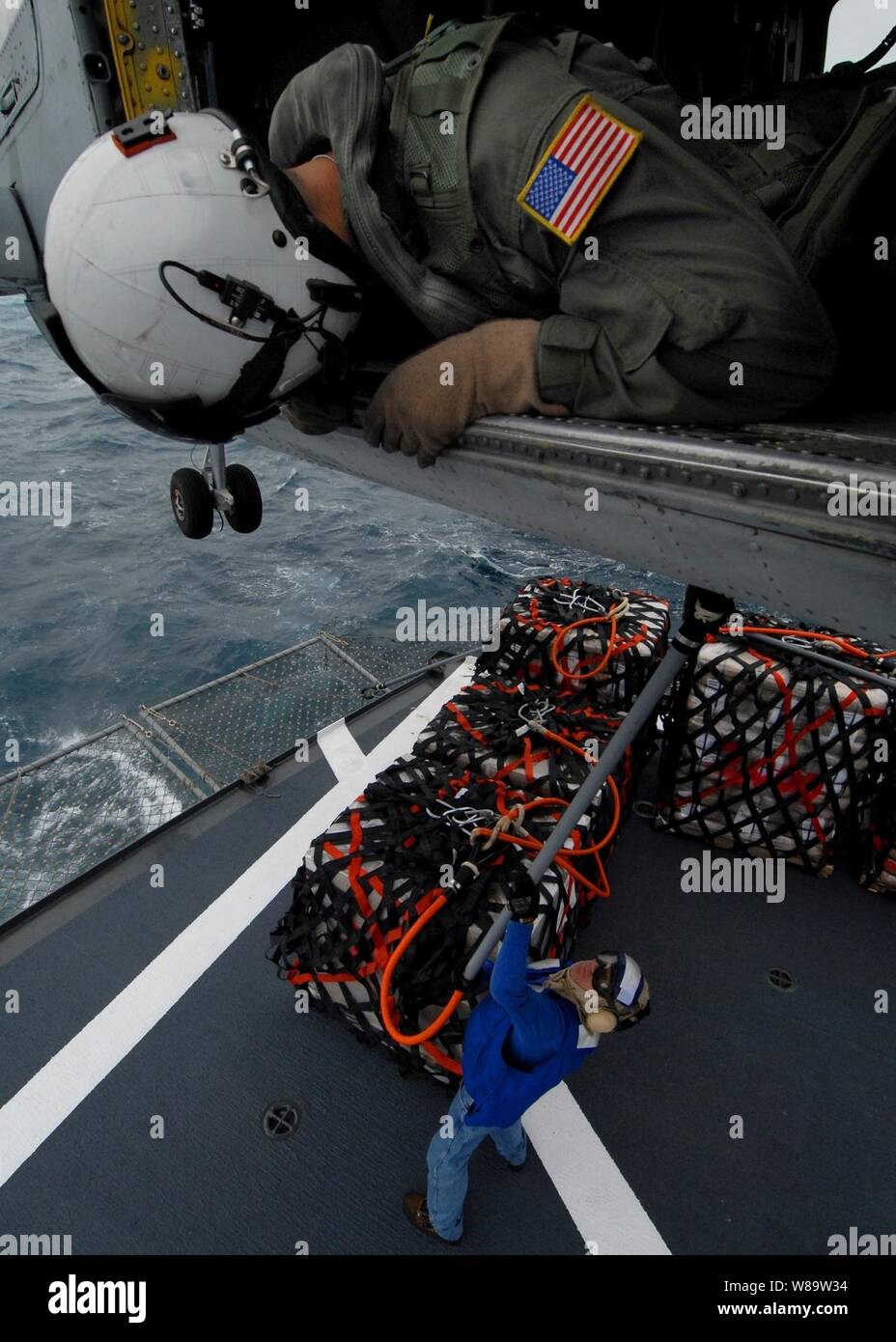 U.S. Navy Petty Officer 2nd Class Tyler Yee watches out the door as a ...