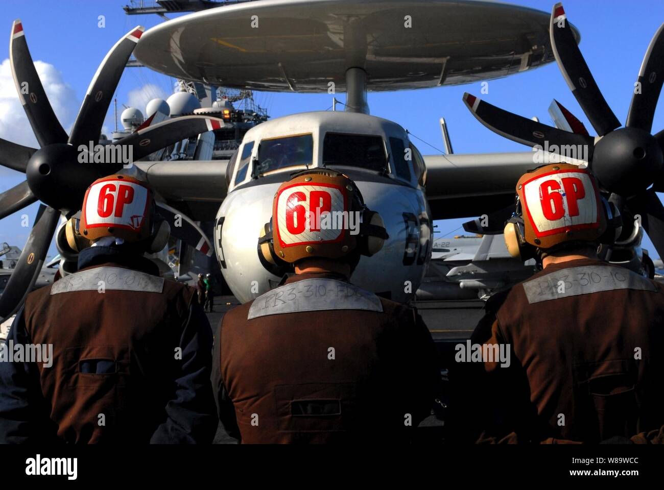 U.S. Navy plane captains await further signals as the pilot of an E-2C ...
