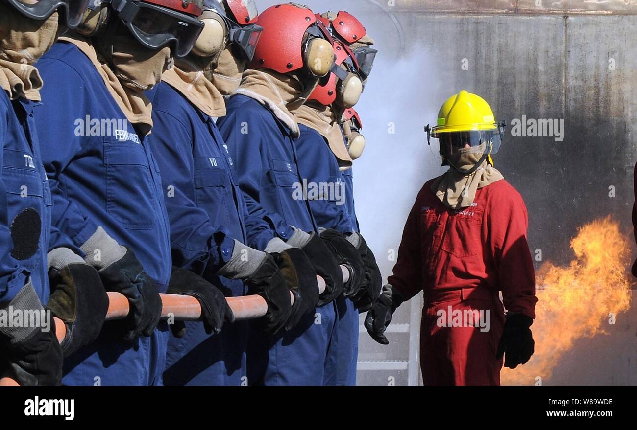 U.S. Navy Petty Officer 1st Class Delbert Corbin (right) lines up ...