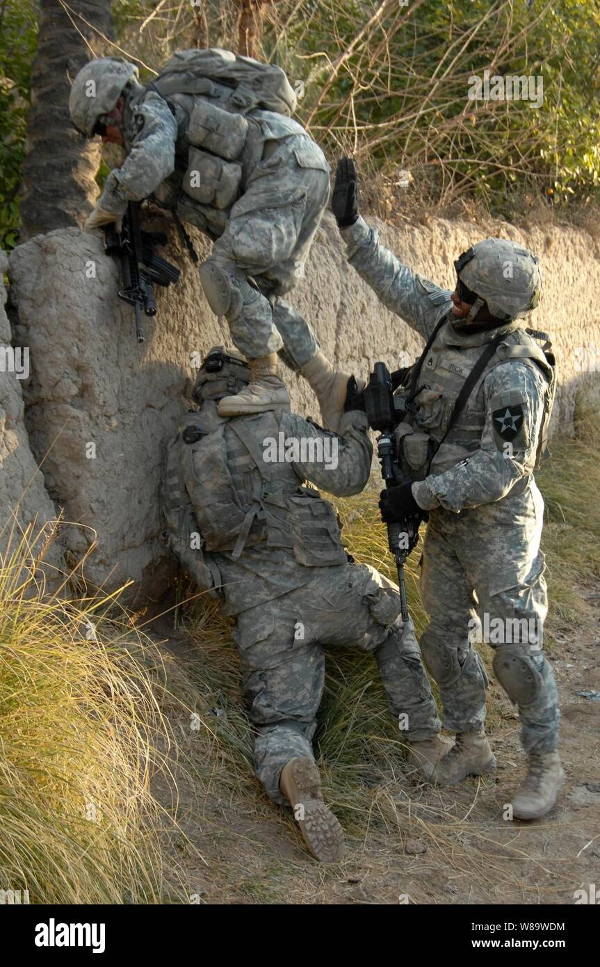 One U.S. Army soldier gets a boost up a wall from his fellow soldiers ...