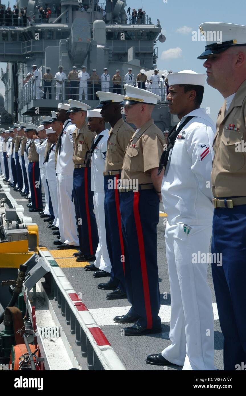 U.S. Navy sailors and Marines man the rails of the amphibious assault ...