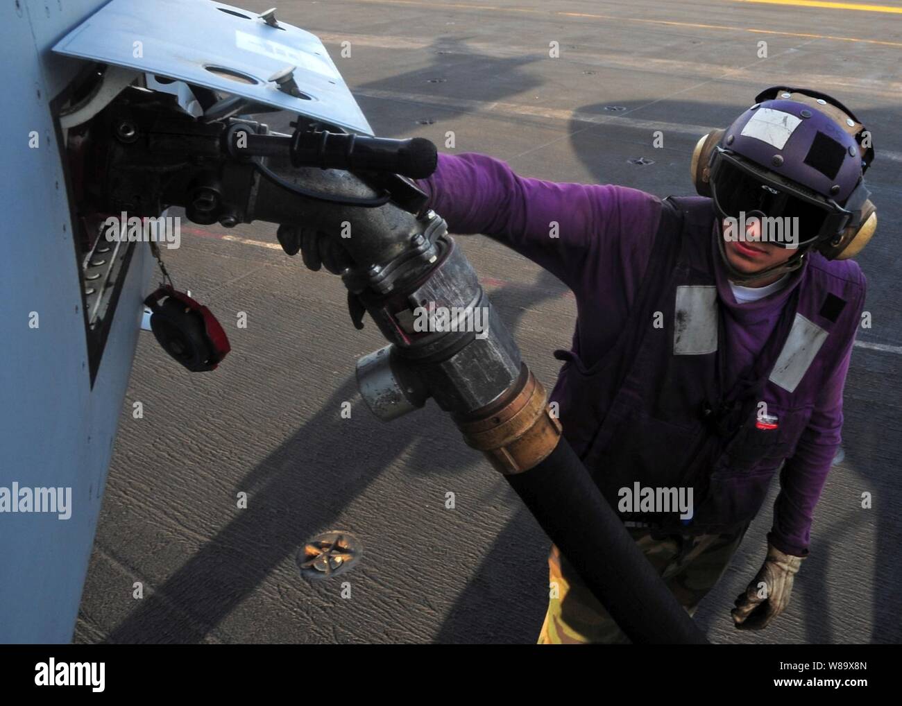 U.S. Navy Airman Joseph Cole fuels an F/A-18 Super Hornet aircraft ...