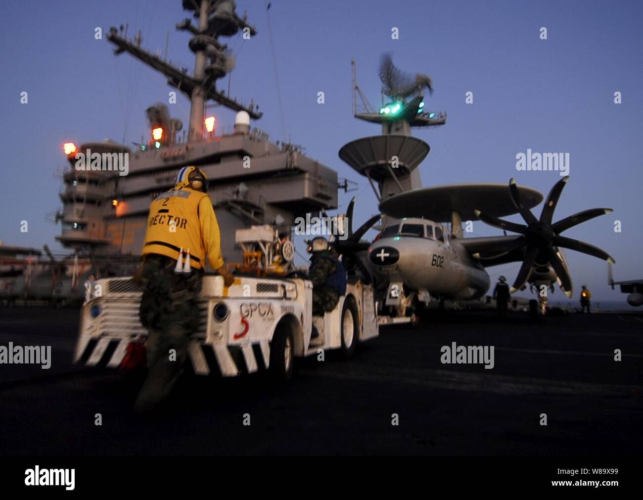U.S. Navy Petty Officer 2nd Class Jose Rodriguez-Gonzalez (left) guides ...