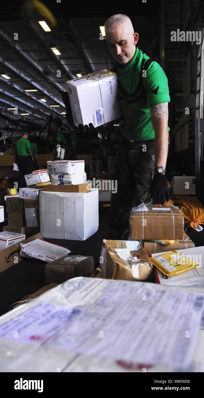 U.S. Navy Petty Officer 2nd Class Damion Kelley sorts mail in the ...