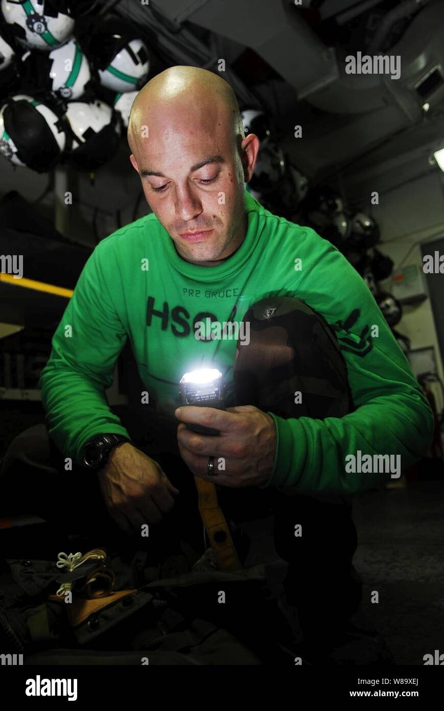 U.S. Navy Petty Officer 2nd Class Jason Bruce checks the emergency ...