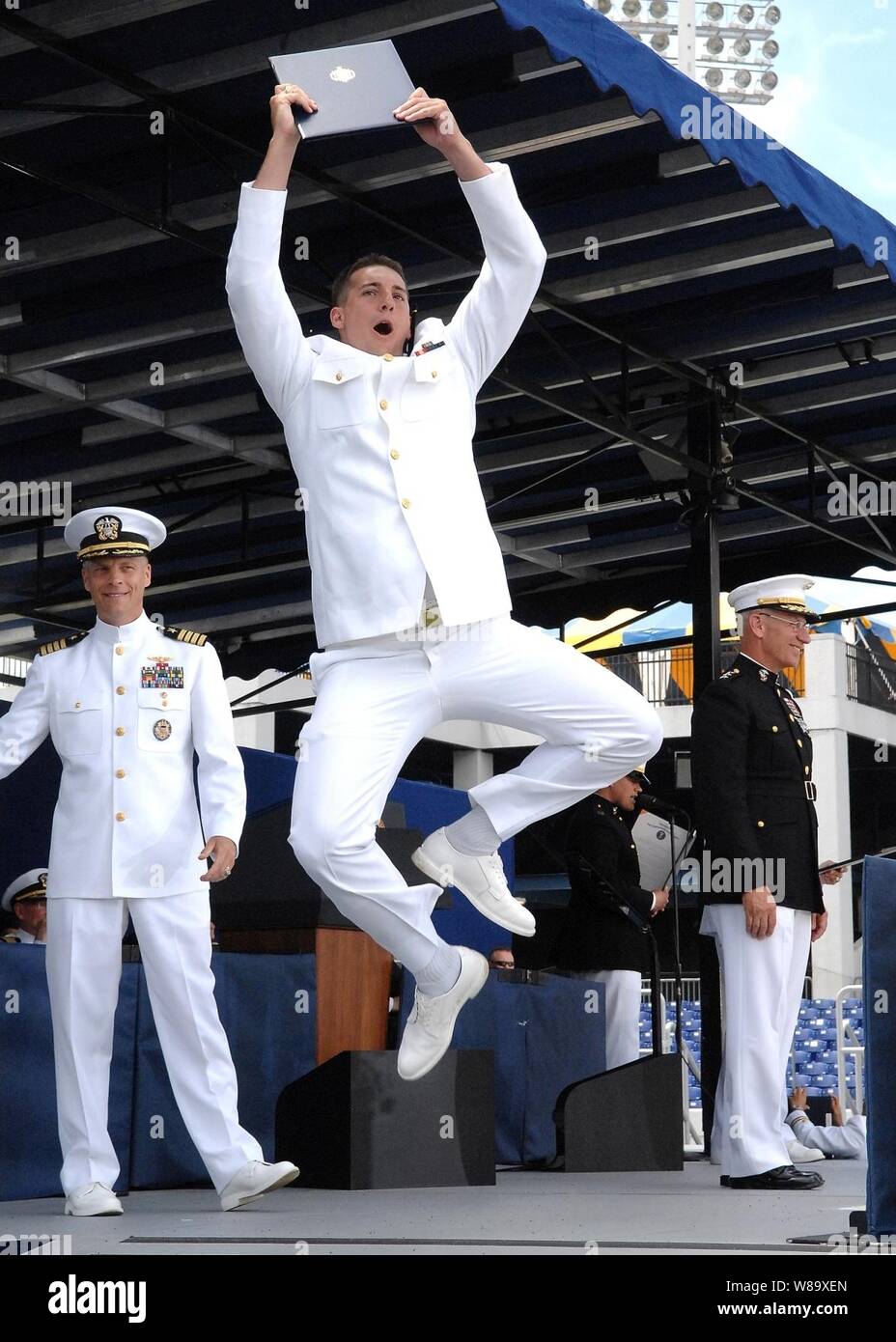 A newly-commissioned U.S. Navy ensign celebrates after receiving his ...