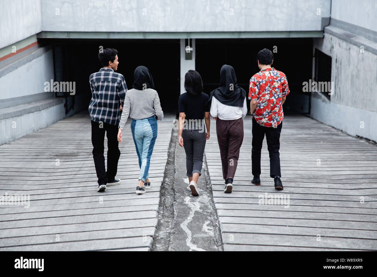 Young friends walk away posing on the way together Stock Photo - Alamy