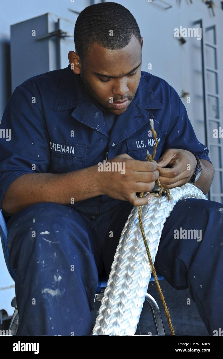 U.S. Navy Seaman Jonathon Foreman splices a tattletale through a new ...