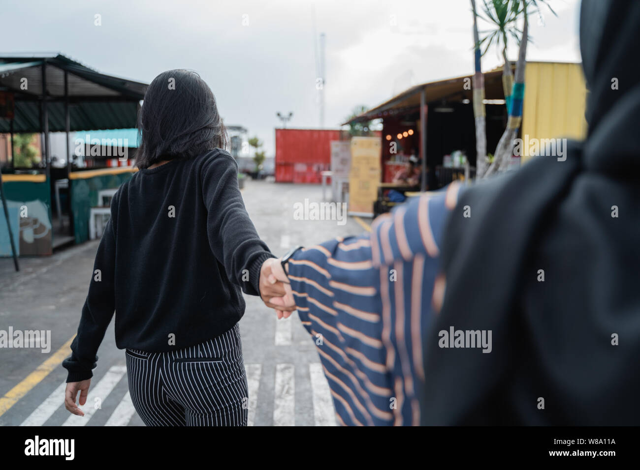 back view of two friends walking together Stock Photo - Alamy