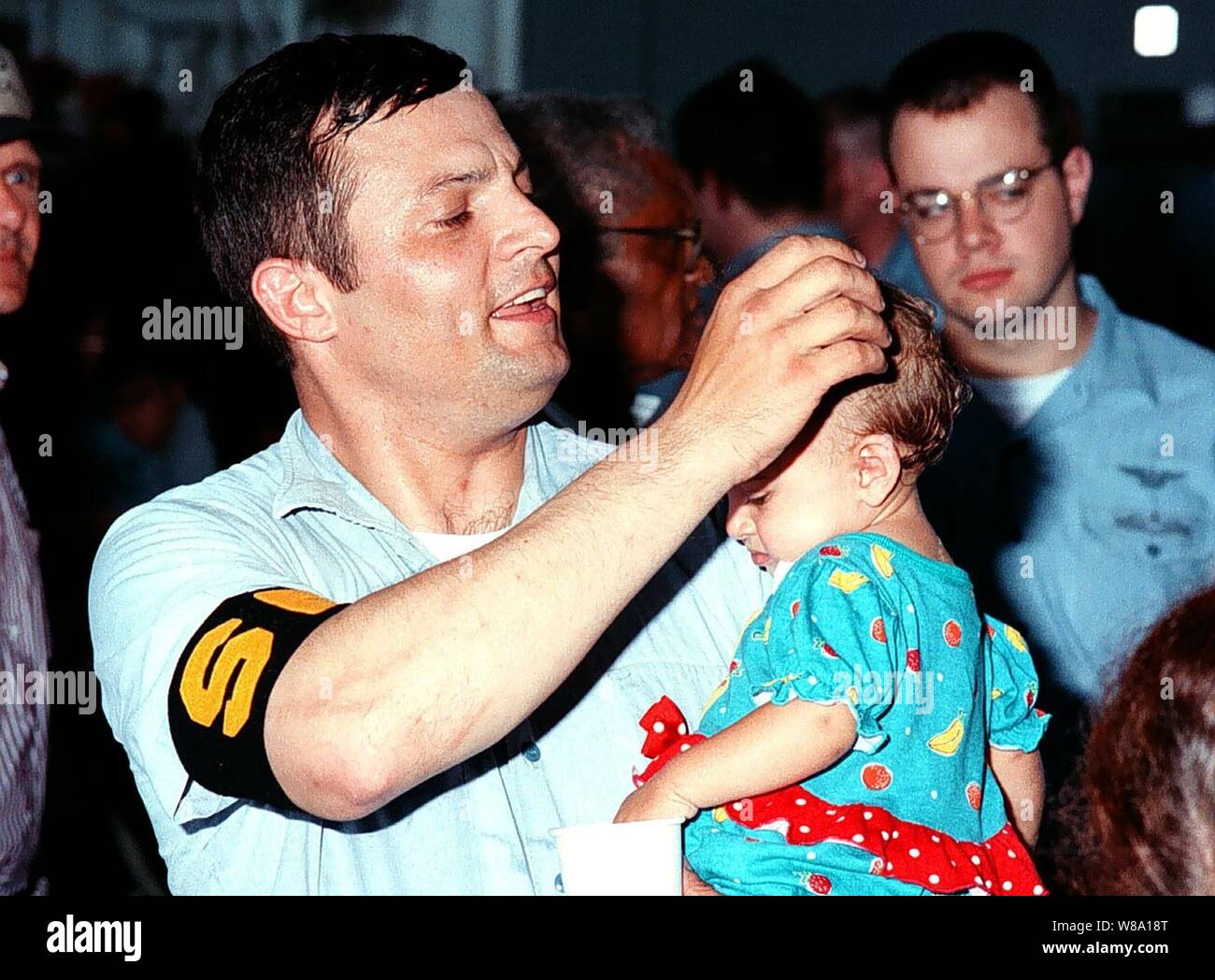 Petty Officer 2nd Class Racey C. Swing comforts an infant evacuee from ...