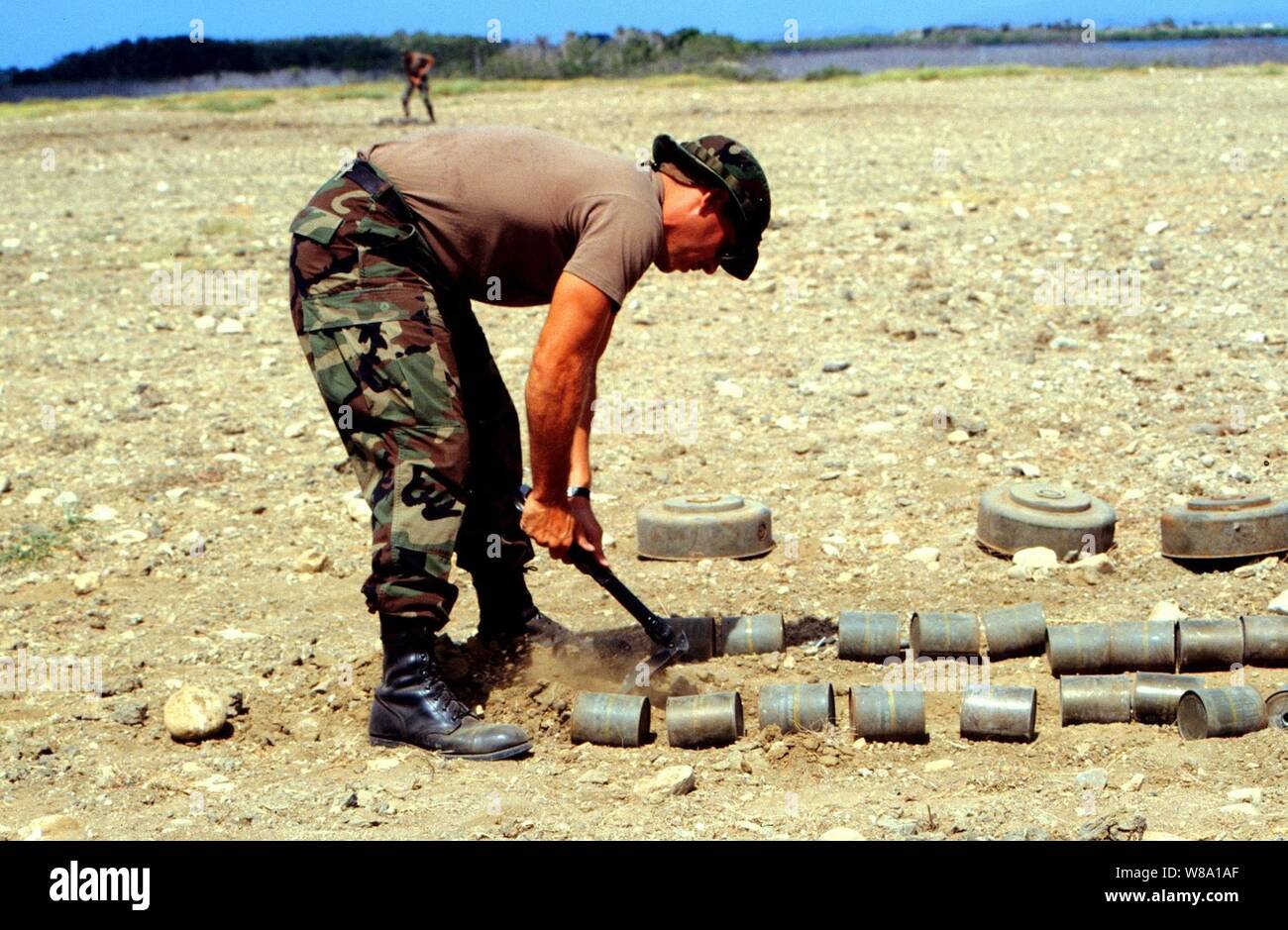 Petty Officer 1st Class Leon Ullel excavates an area to stack anti-tank ...