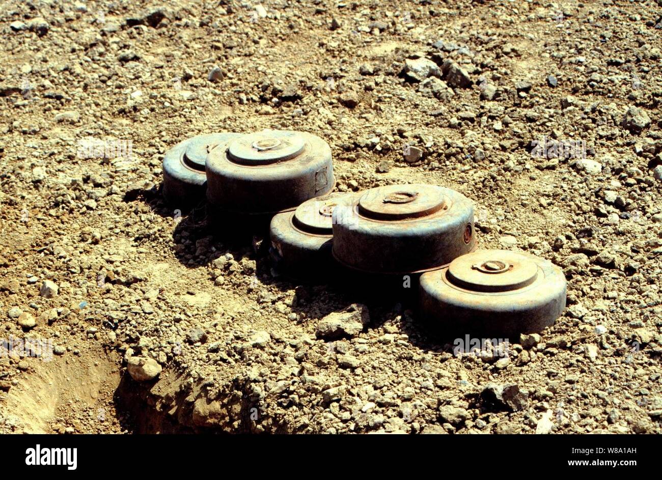 Five M15 anti-tank land mines are stacked for destruction at a ...