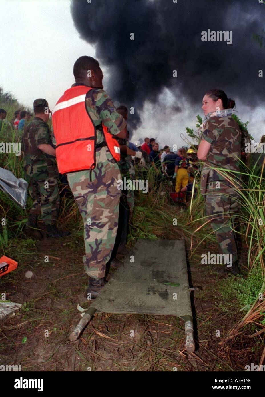 U.S. Navy and U.S. Air Force rescue personnel stand by to assist in the ...