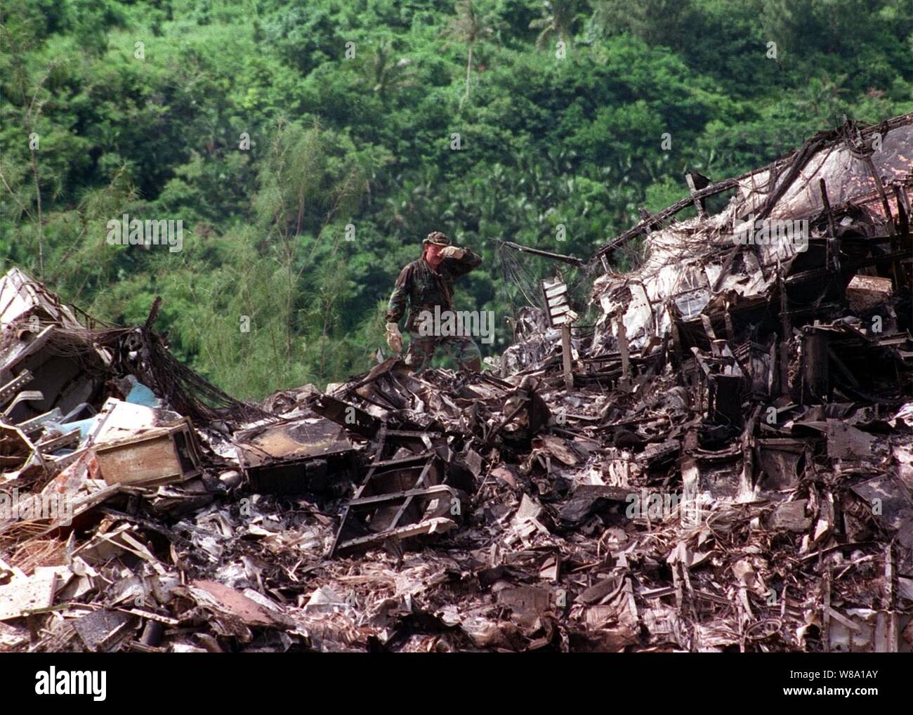 A rescuer atop the wreckage of KAL Flight 801. U.S. Navy, Air Force ...