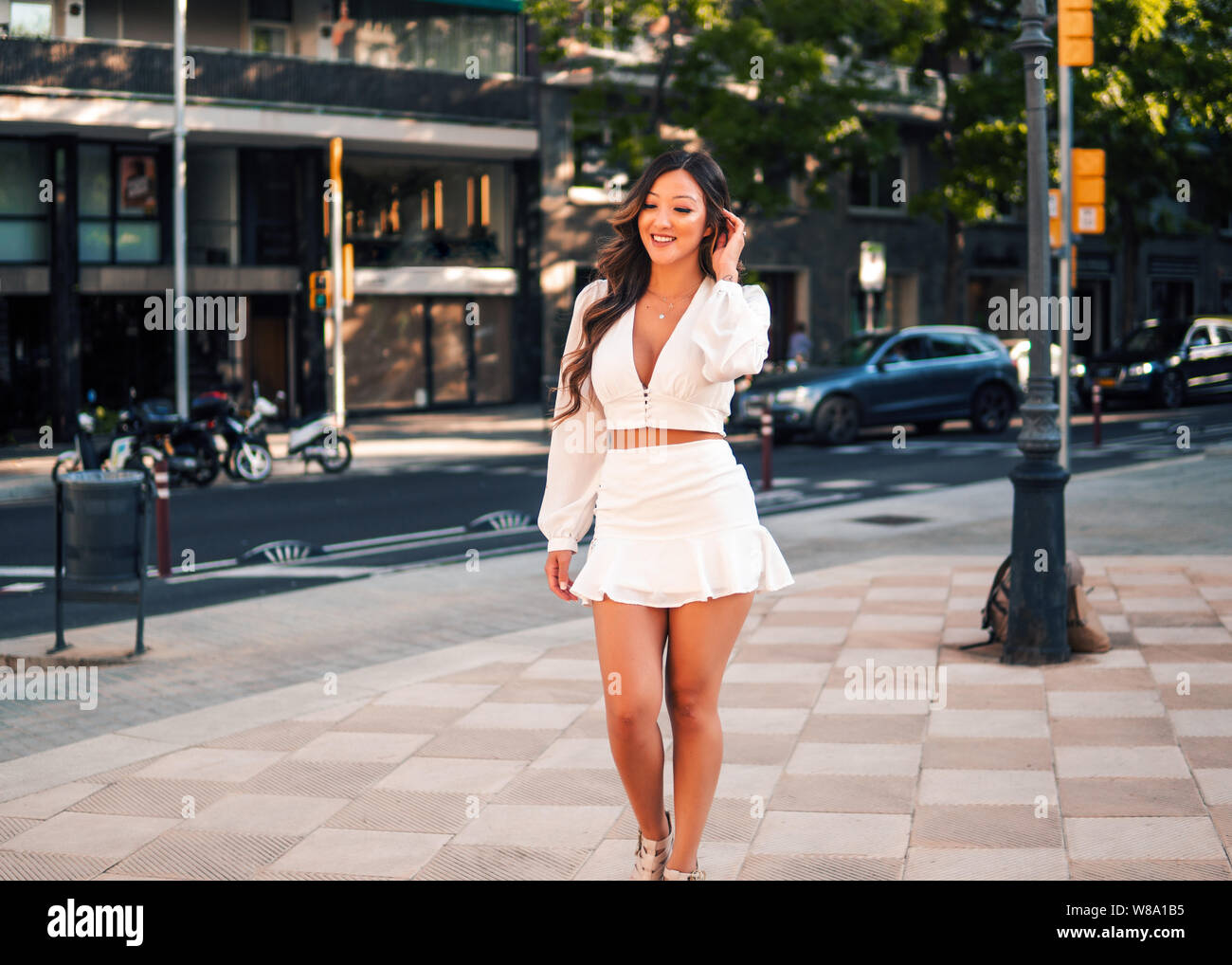 portrait of young stylish asian girl on the street of big modern city ...