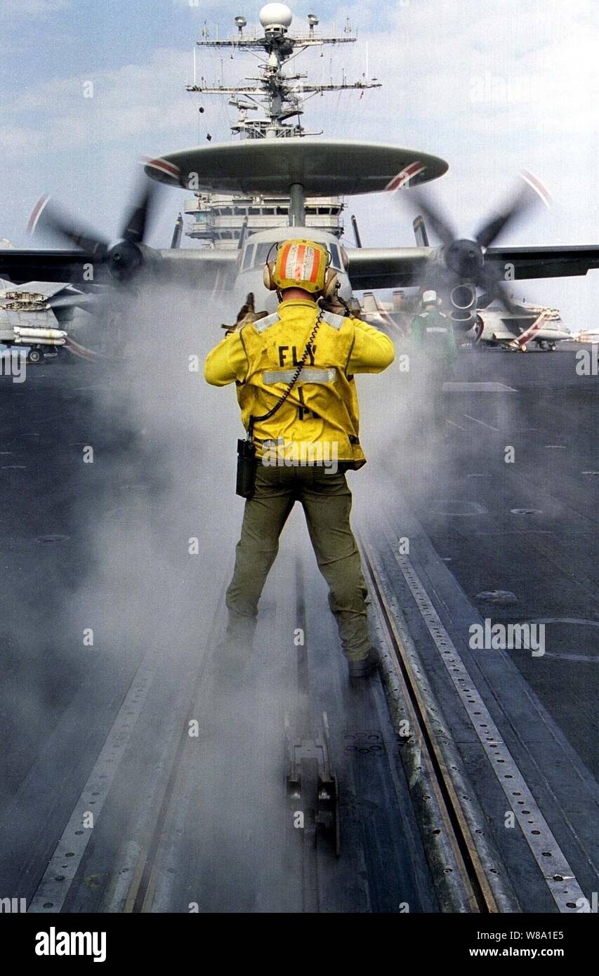 Petty Officer 3rd Class Kevin P. Spurrell directs an E-2C Hawkeye onto ...