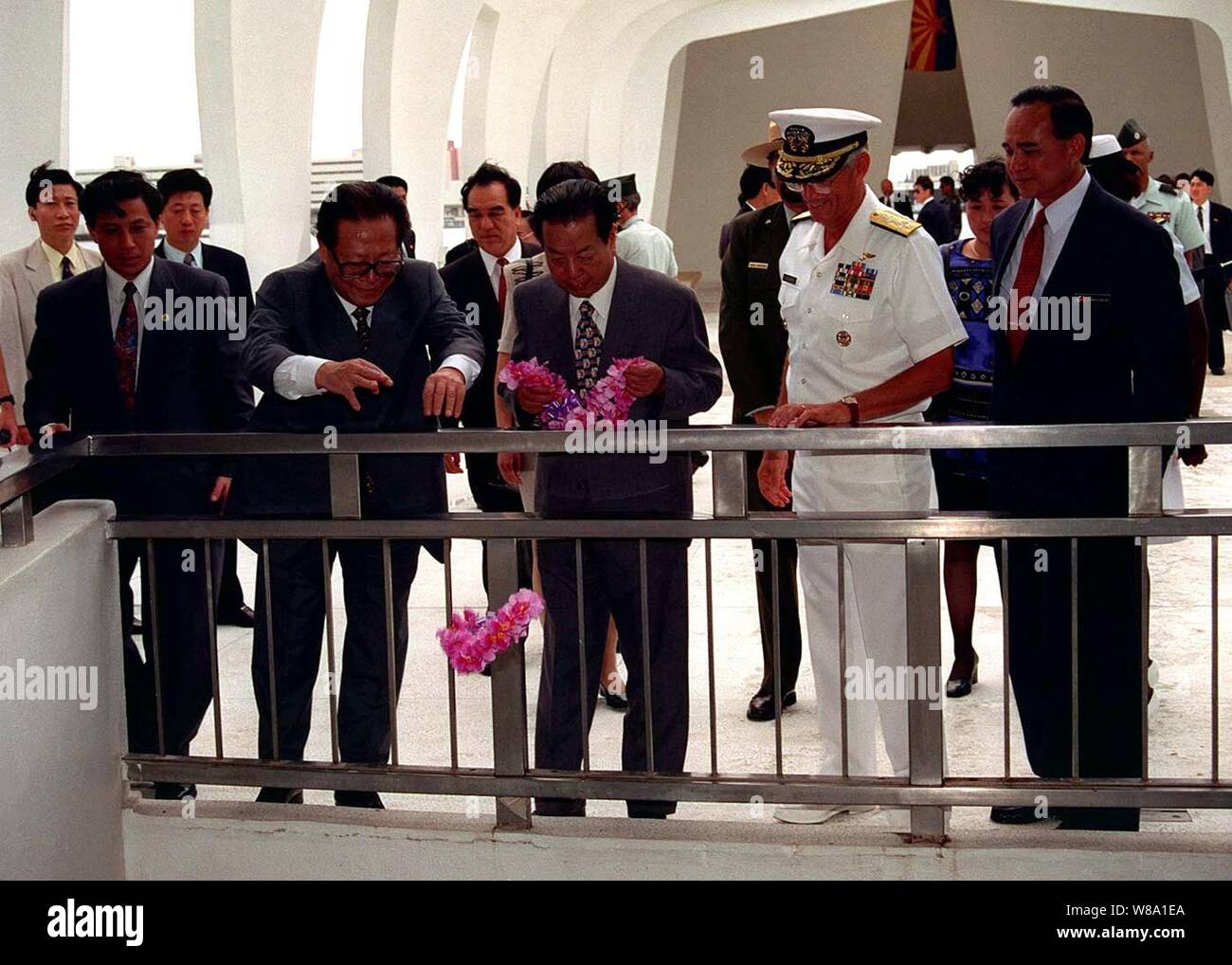 Chinese President Jiang Zemin (left) drops a lei into the viewing well ...