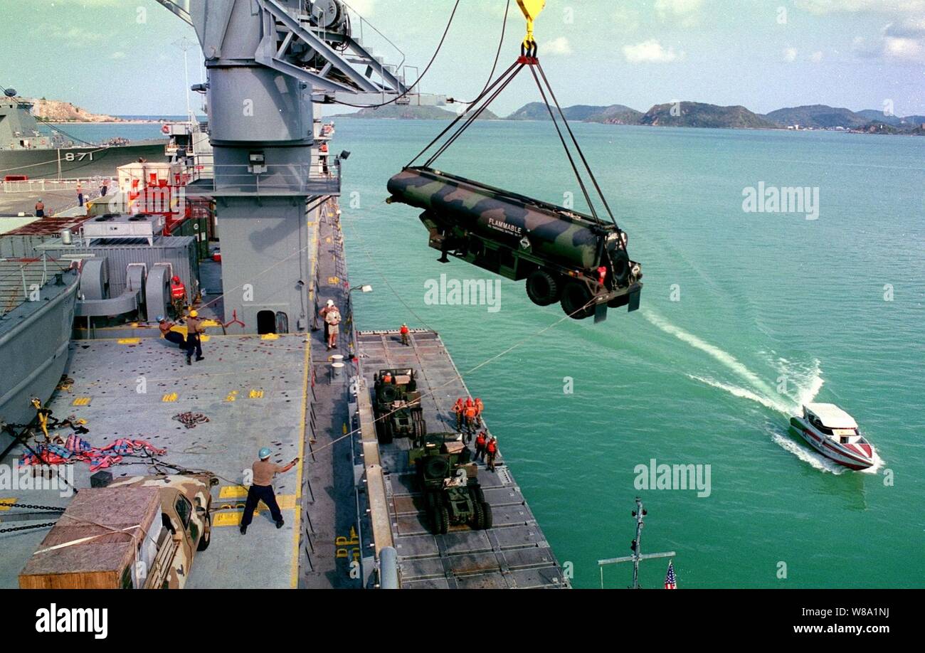 Sailors and Marines guide a tanker trailer as it is lowered over the ...