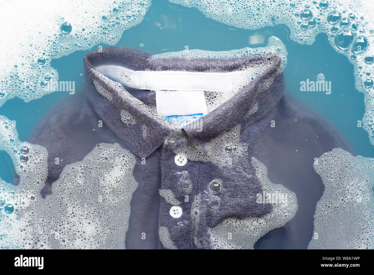 Grey polo shirt soak in powder detergent water dissolution, washing ...